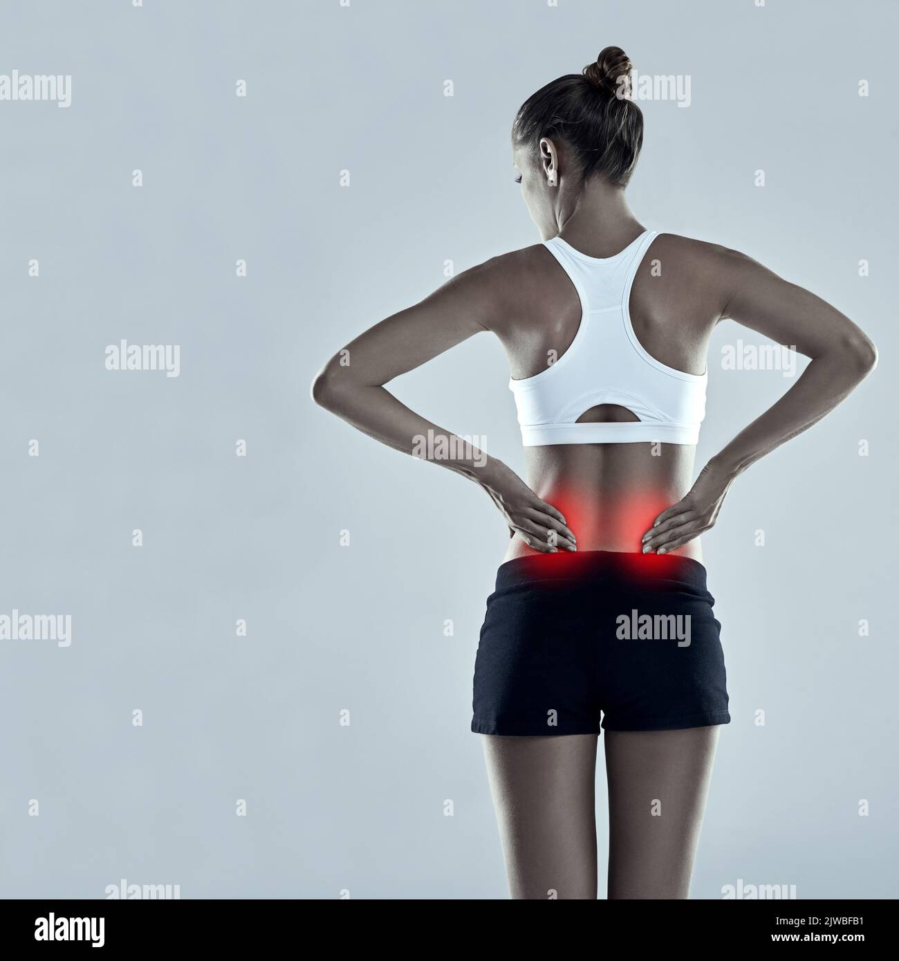 Lower back pain is no joke. Studio shot of an athletic young woman ...
