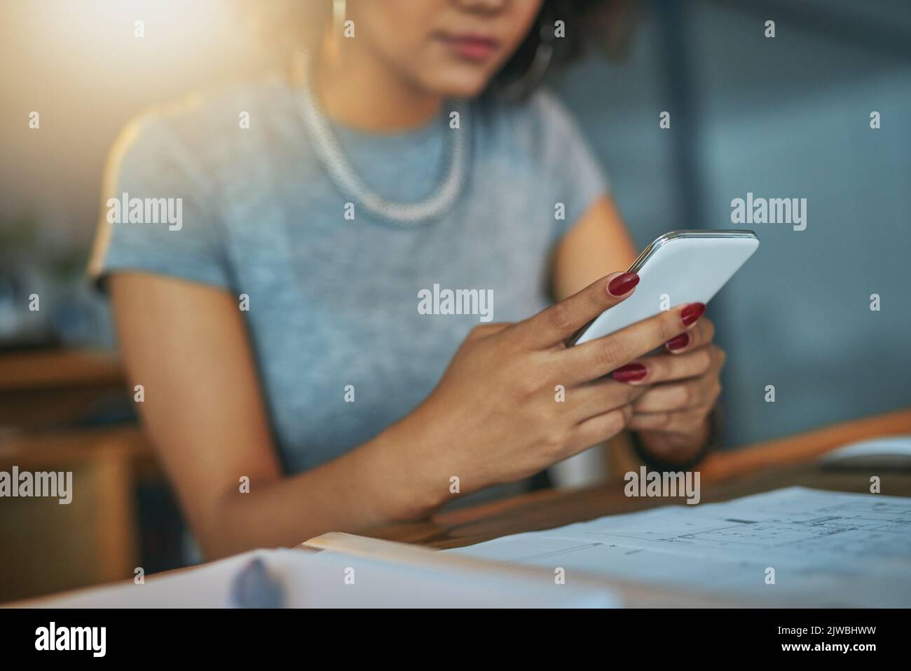 Available to her clients 247. a woman using a phone during a late shift ...