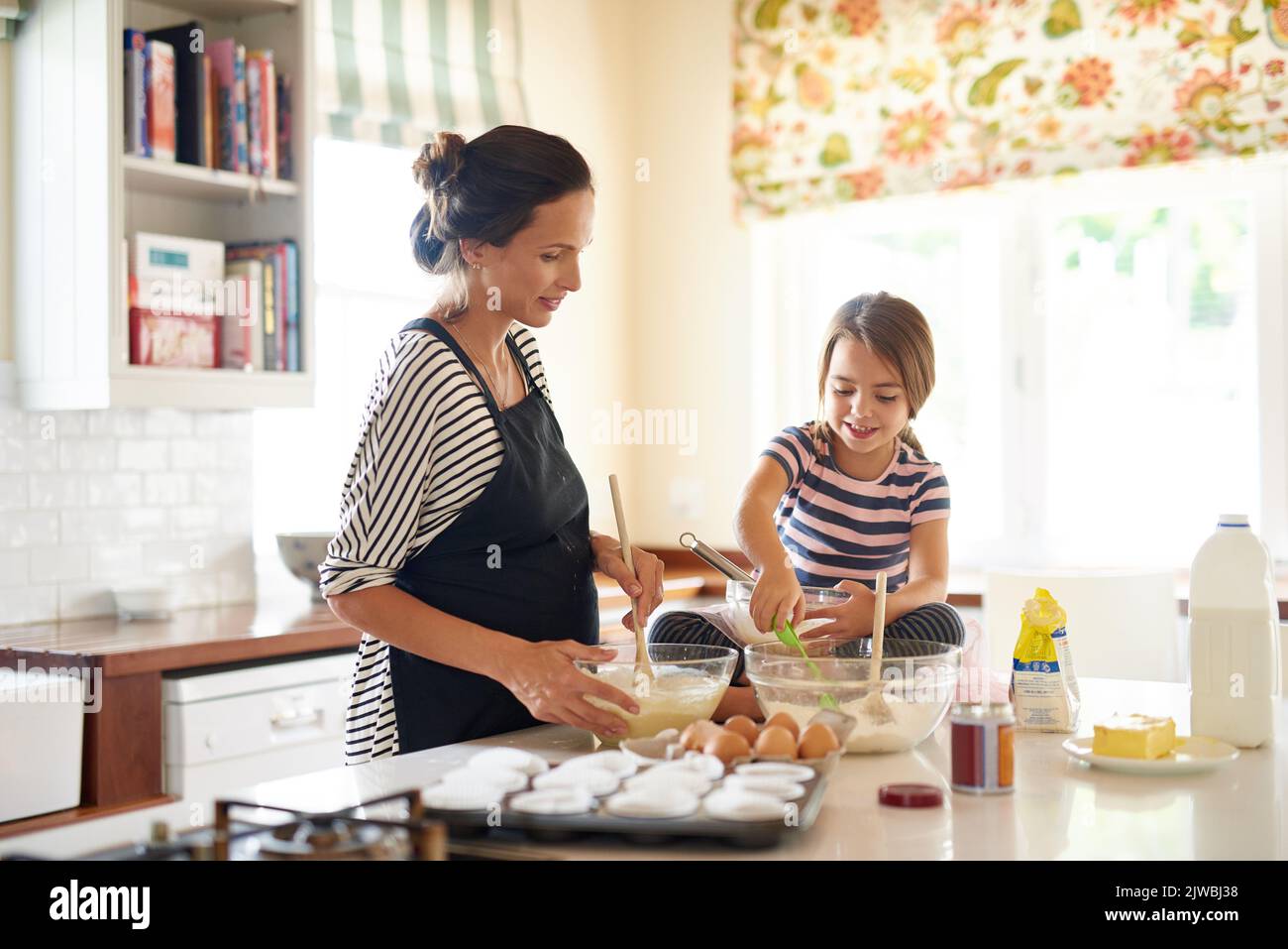 Making something sweet with mommy. a little girl baking with her mother ...