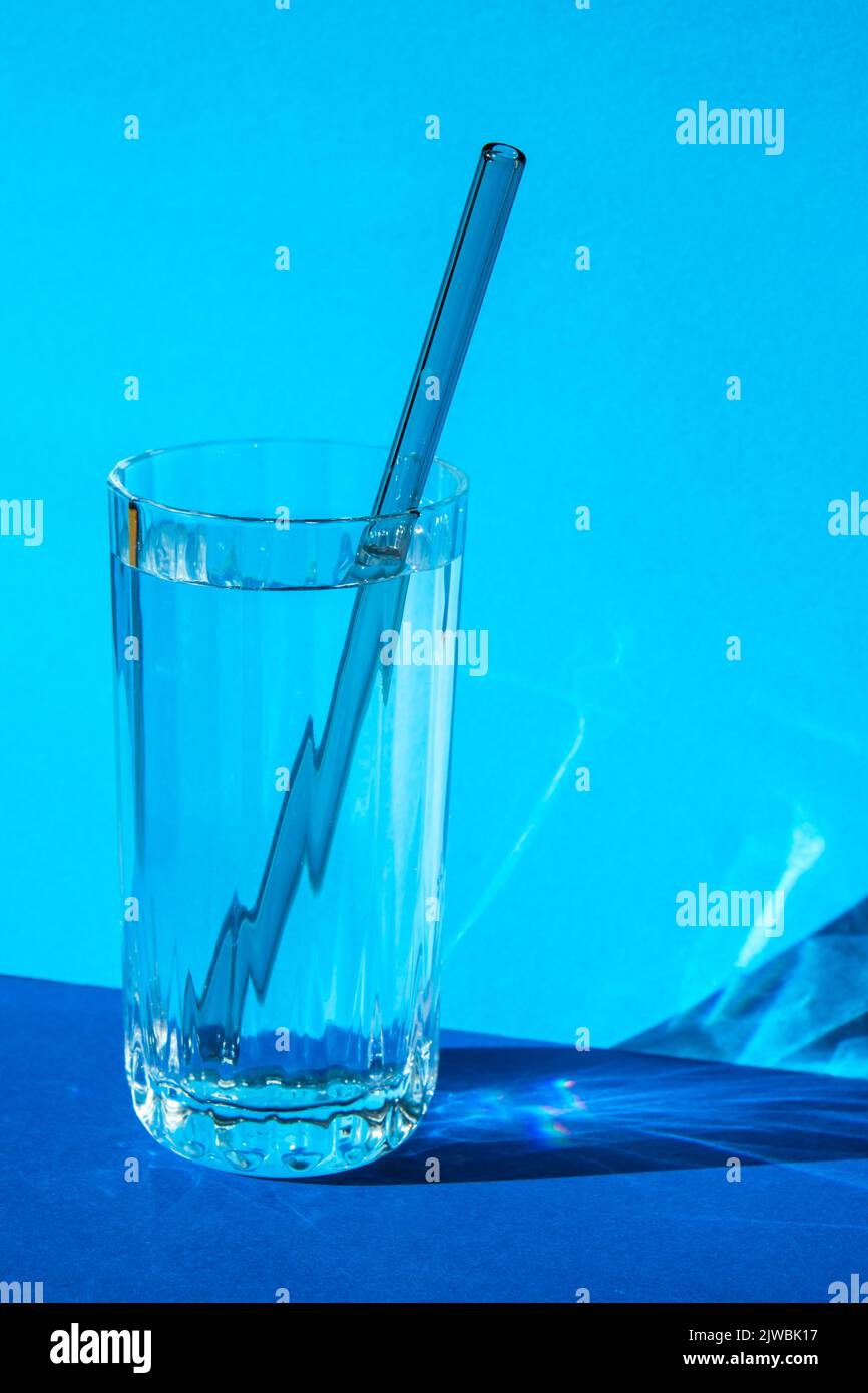 Reusable glass Straws in Glass with water on blue background Eco ...