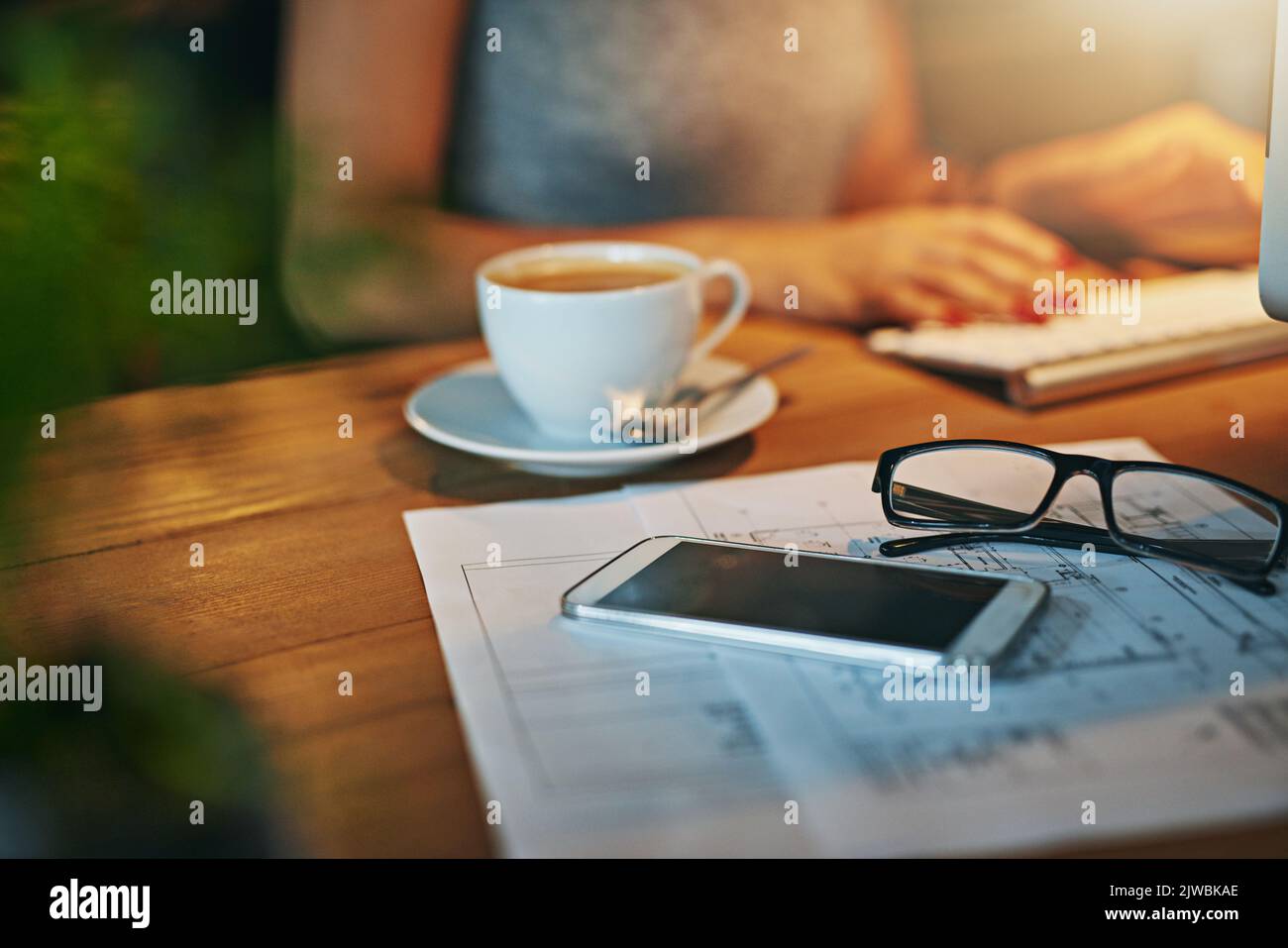 More hours, more success. a woman working on a computer with coffee, a ...