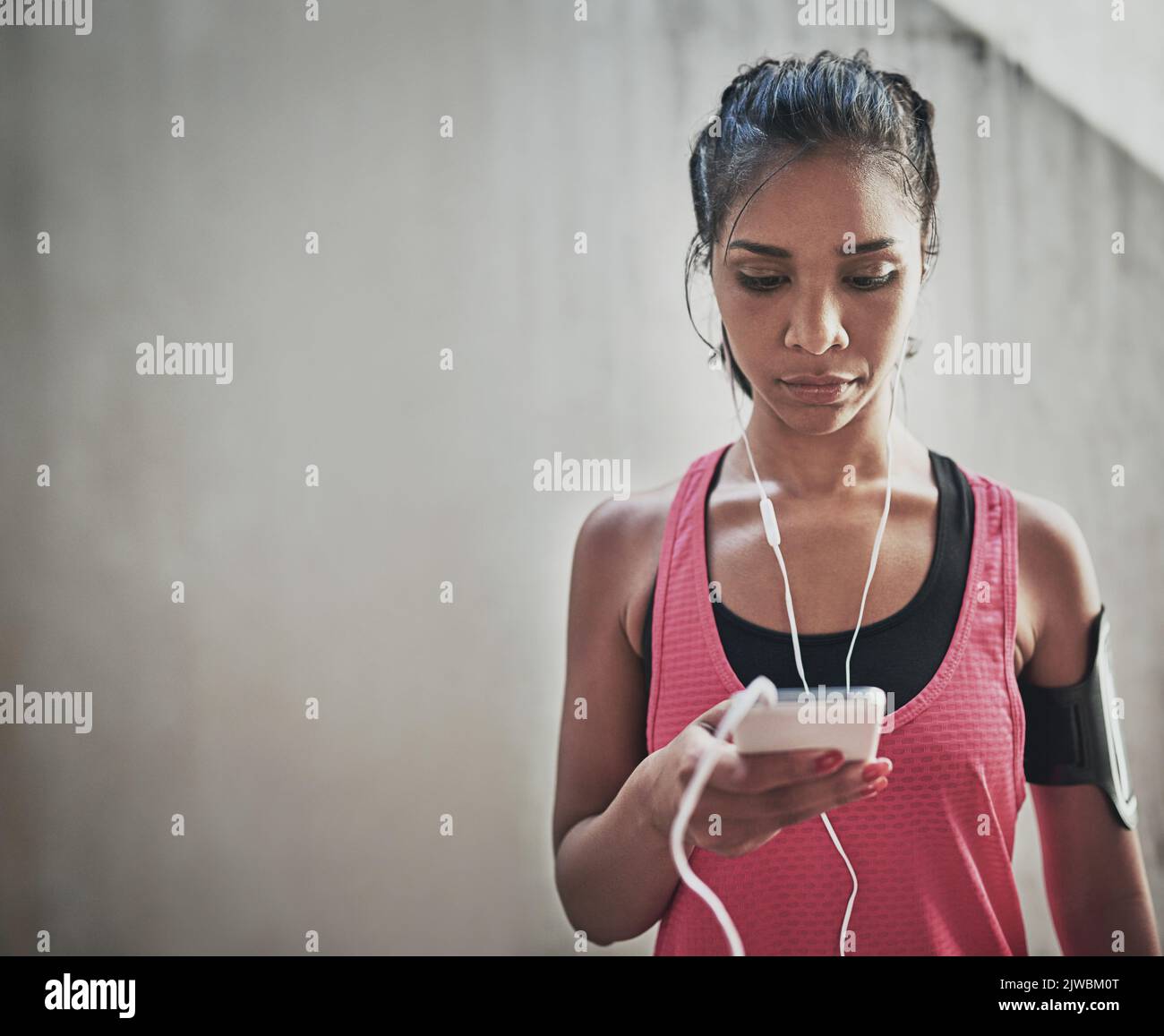 Selecting her favourite workout tracks. a sporty young woman listening ...