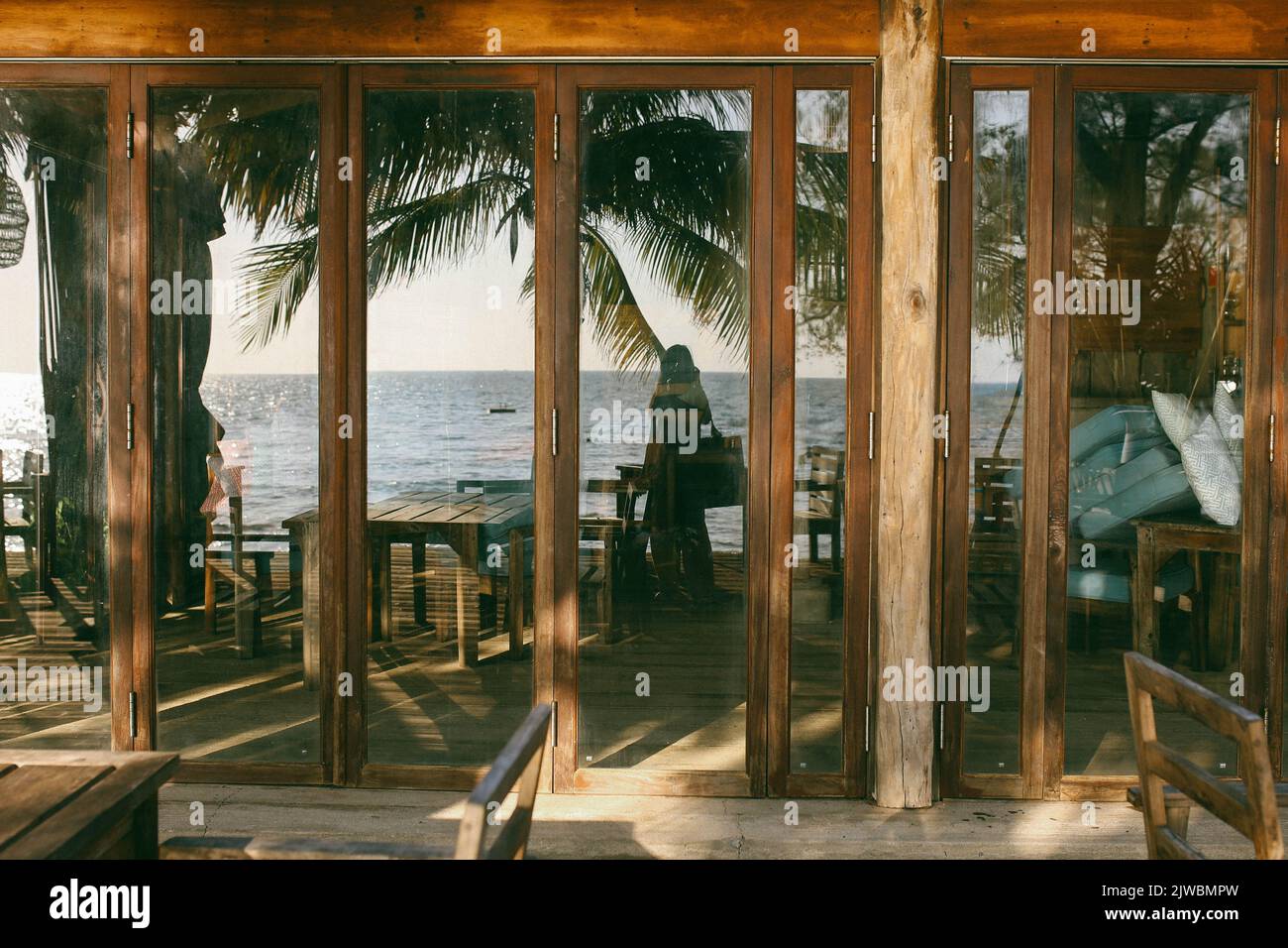 Reflection through the door of a restaurant with ocean background Stock ...