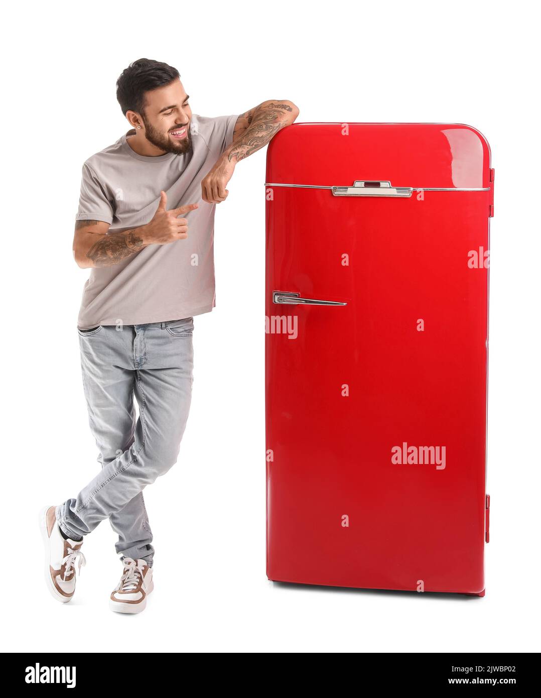 Cool tattooed young man near red fridge isolated on white Stock Photo ...