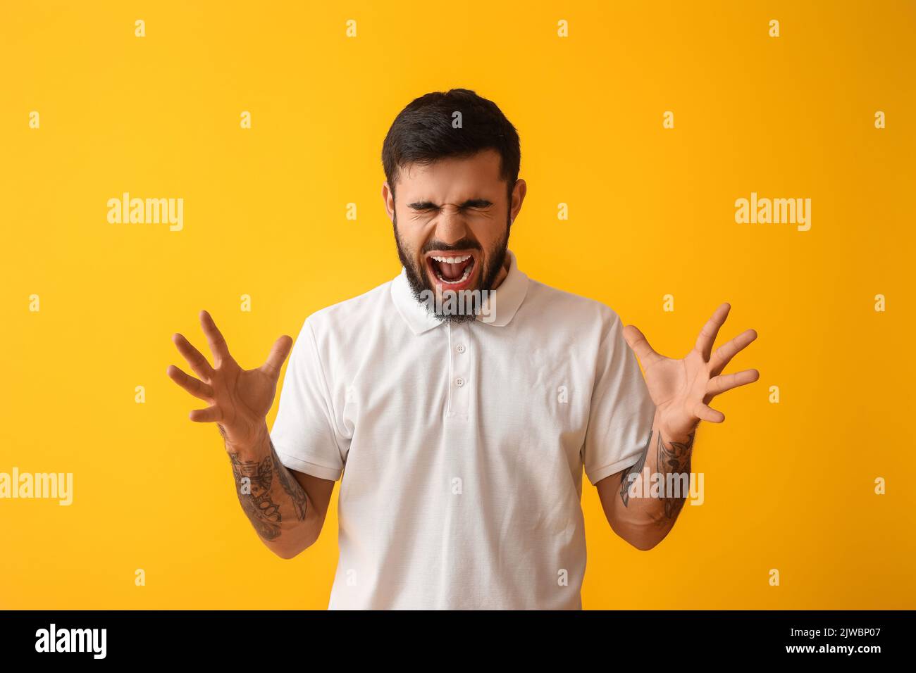 Portrait of stressed angry bearded man on yellow background Stock Photo ...