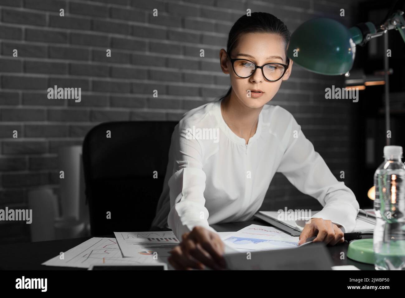 Beautiful businesswoman working with documents in office at night Stock ...