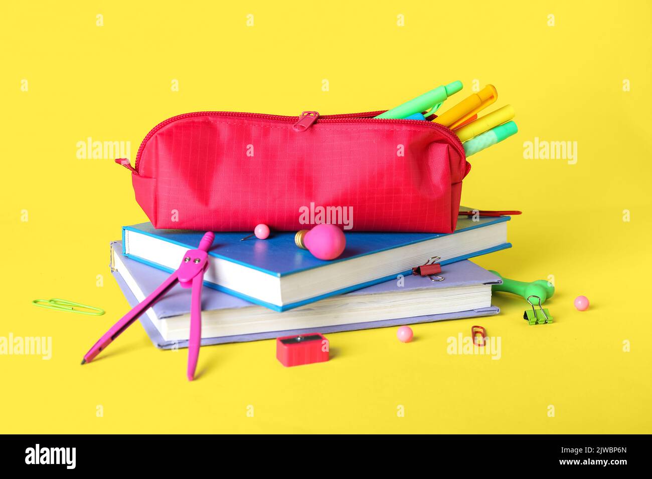 Red pencil case with school stationery on yellow background Stock Photo ...