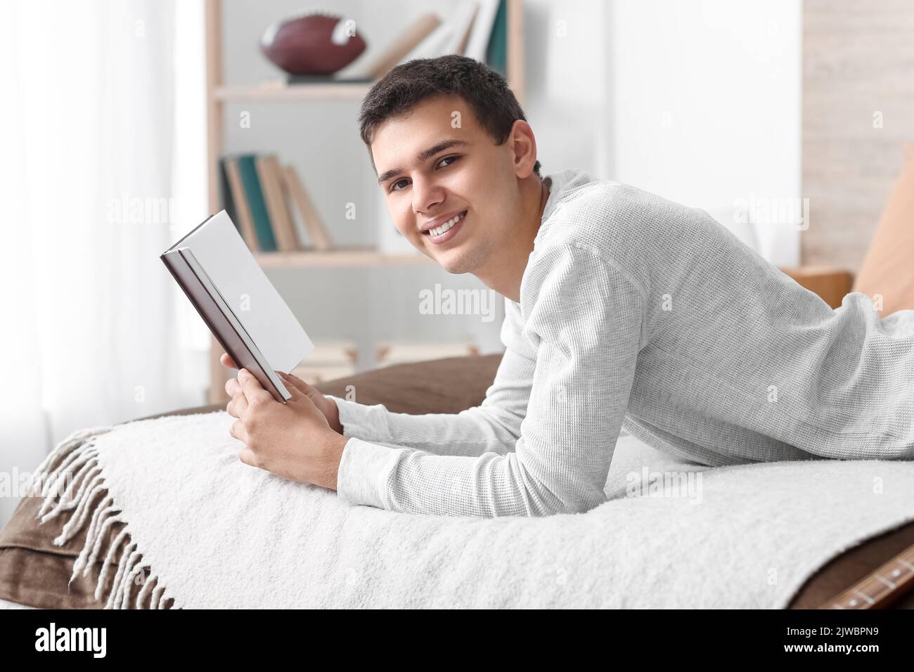 Teenage boy reading book in bedroom Stock Photo - Alamy