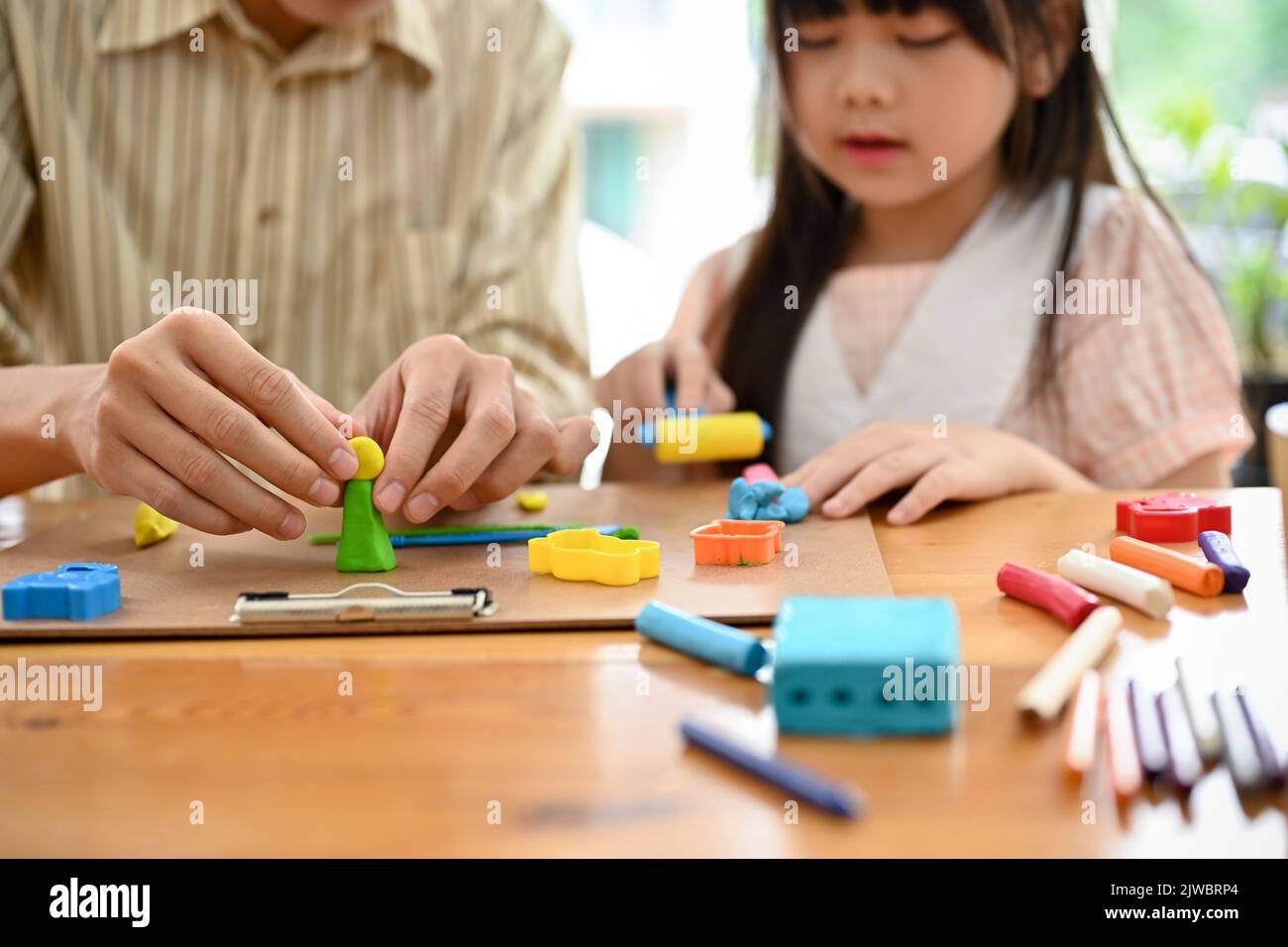 Happy Asian dad and daughter enjoys moulding colorful clay or play ...