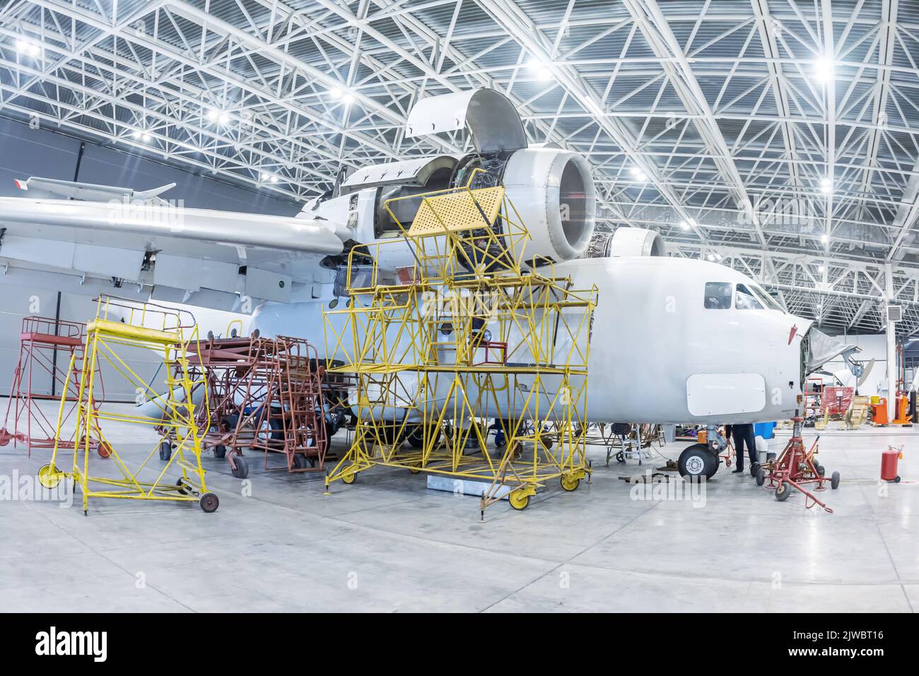 White transport aircraft in the hangar. Airplane under maintenance ...