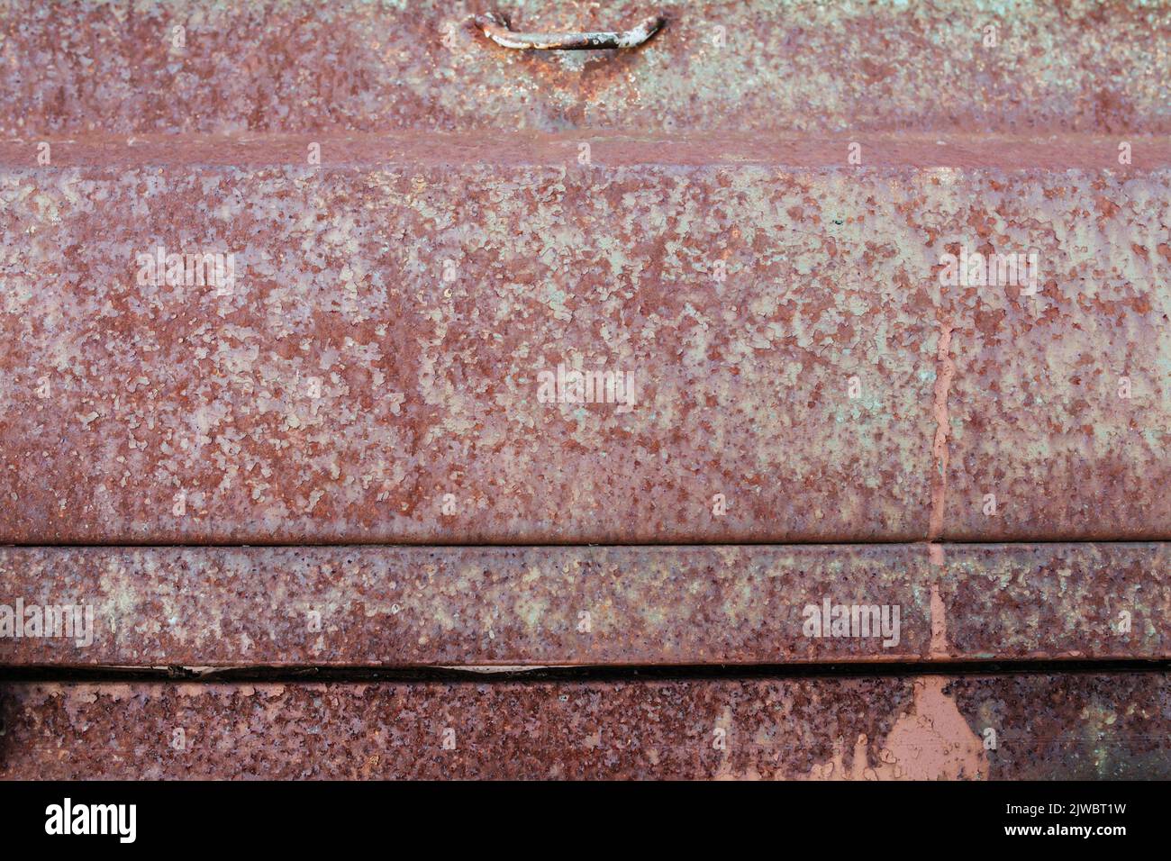 Close up side view of a red old degraded metal box with a lid. Texture ...