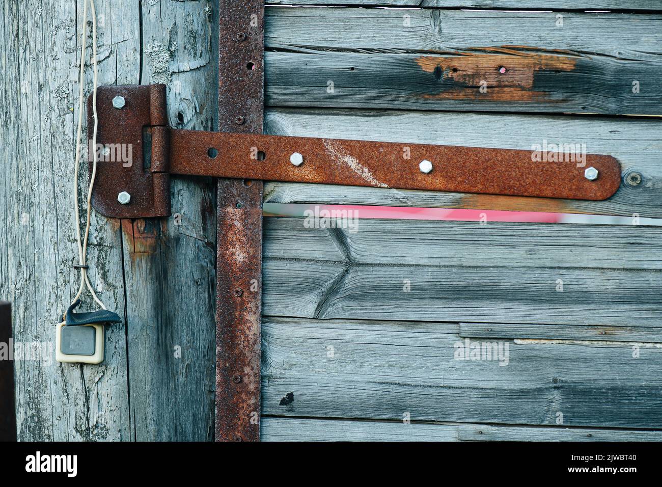 Rusted strap hinge on a fence gate door made from withered grey wood ...