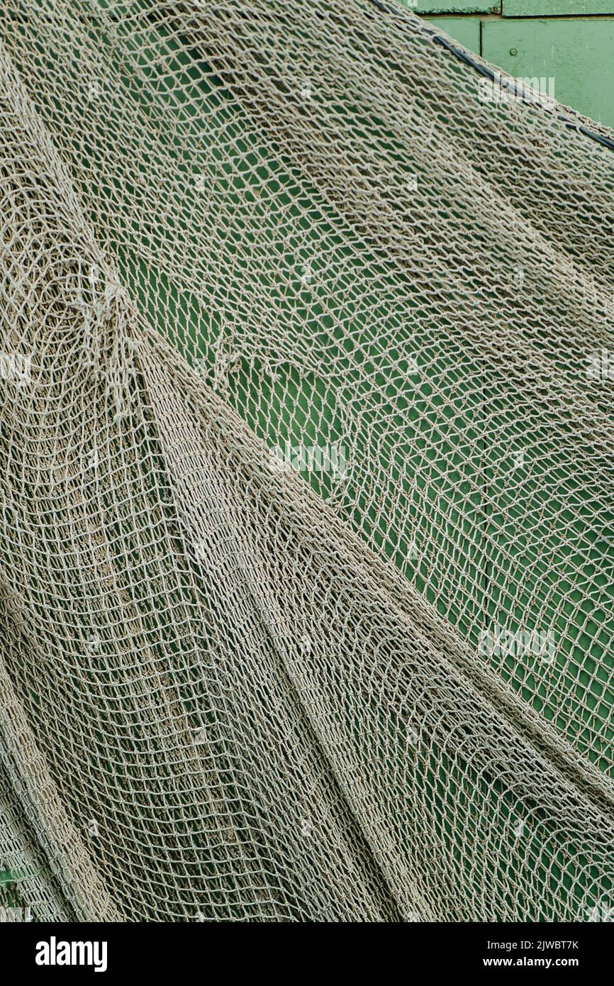 Old fishing net hanging on a old decayed green painted plywood wall of ...