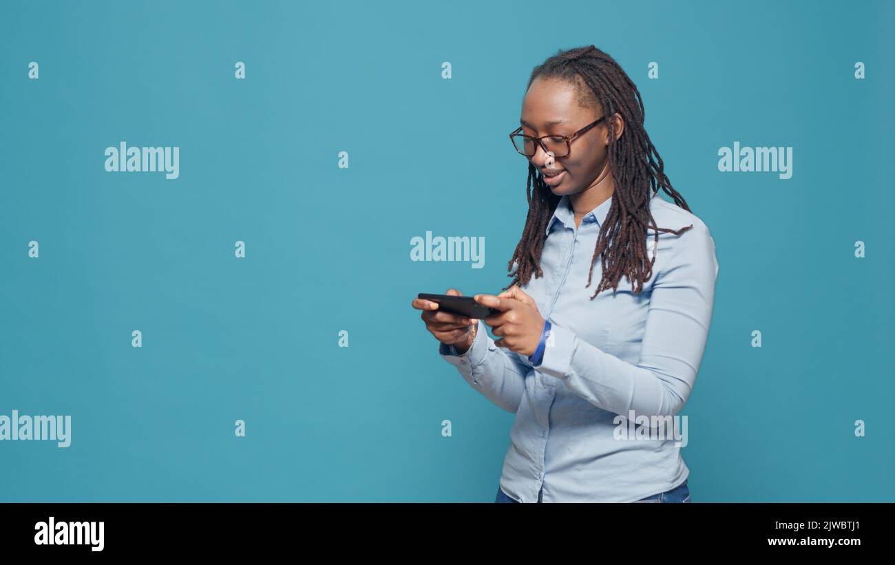African american gamer playing video games on smartphone, having fun ...