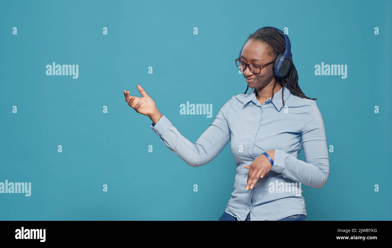 Cheerful person playing air guitar on camera, looking like rockstar to ...
