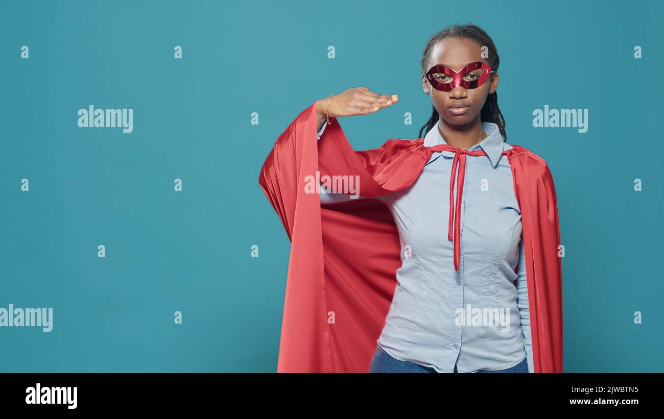 Portrait of woman superhero doing military salute to show motivation ...