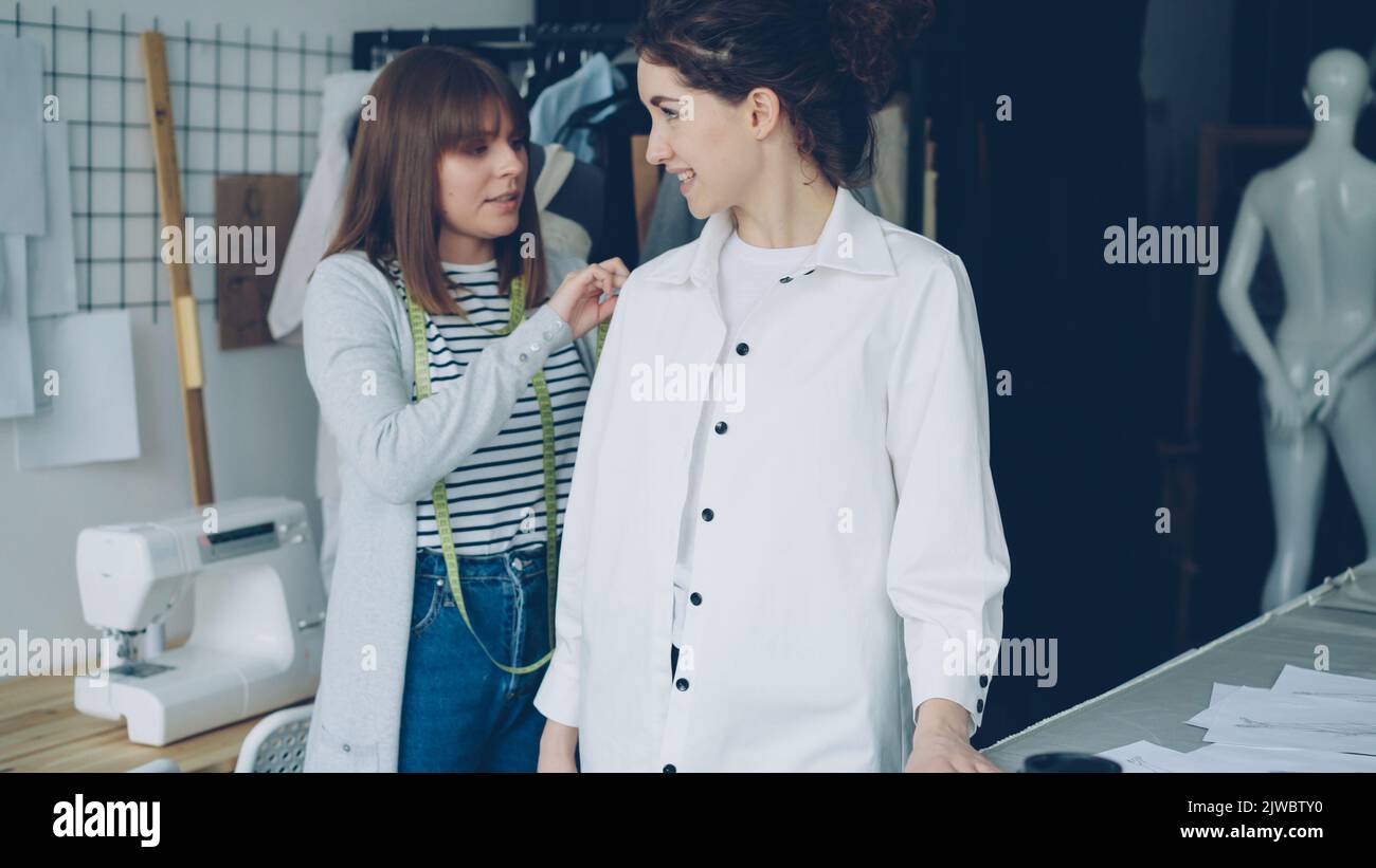 Pretty customer is trying on tailored shirt and sharing her opinion ...