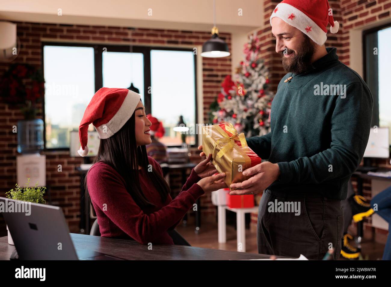 Business man giving christmas gift to woman in office, celebrating ...