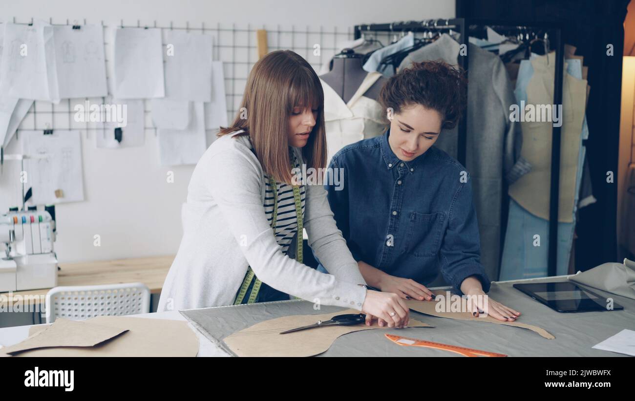 Team of creative designers is working with clothing patterns and fabric ...