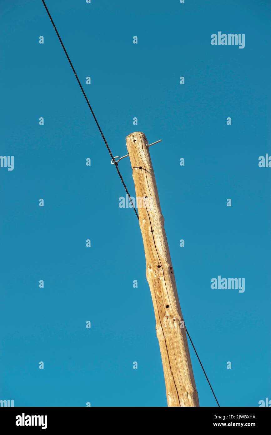 simple wooden pillar with single wire atop Stock Photo - Alamy
