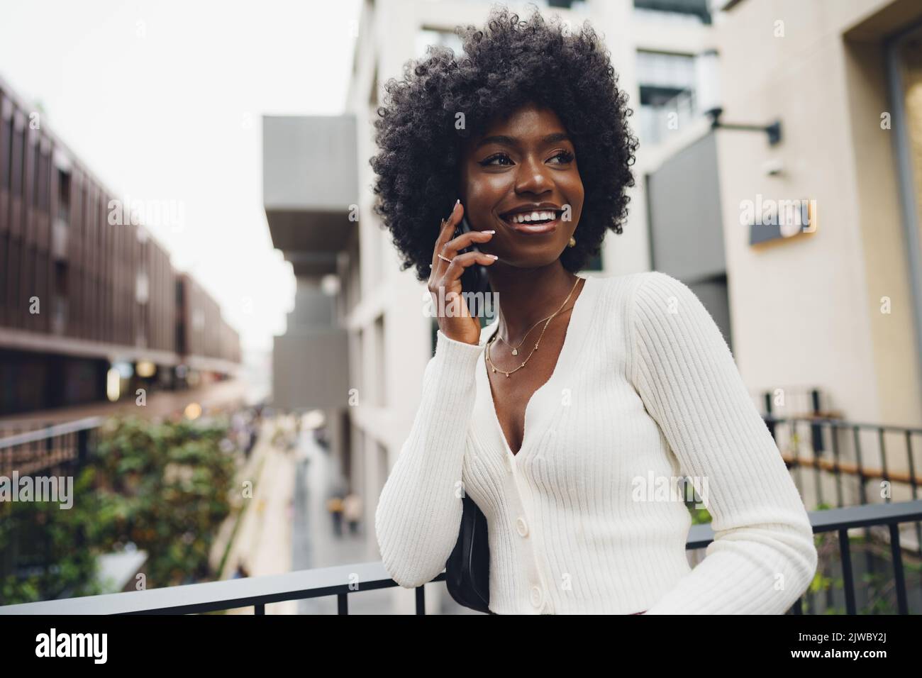 Black afro woman talking on mobile phone in the city Stock Photo - Alamy