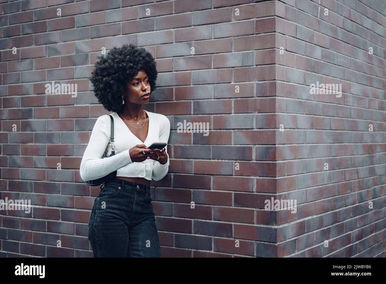 Beautiful young african woman using mobile phone in the street Stock ...
