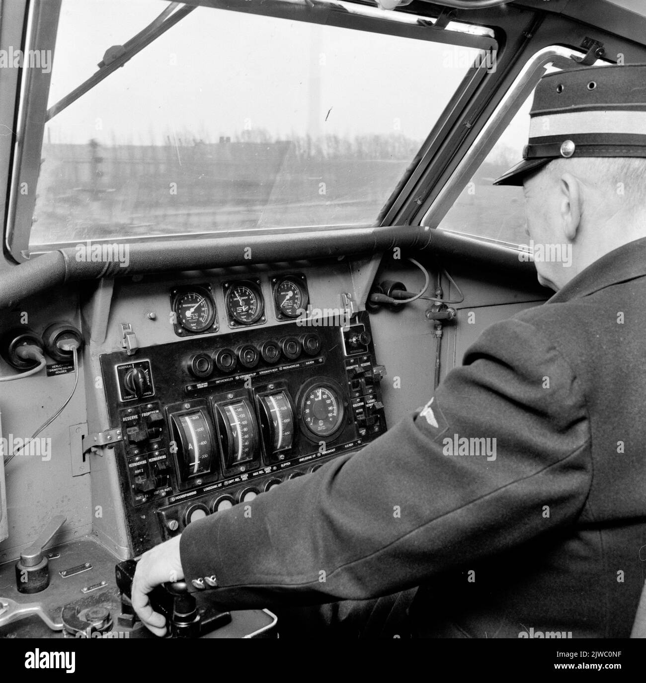 Image of a driver in the cabin (steering position) of an electric train ...