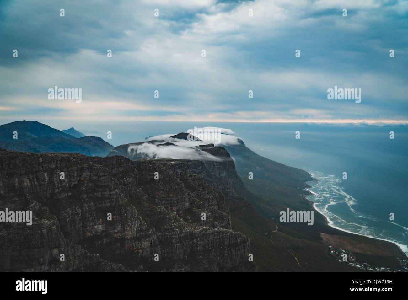Tall cliffs near the ocean under a cloudy sky Stock Photo - Alamy