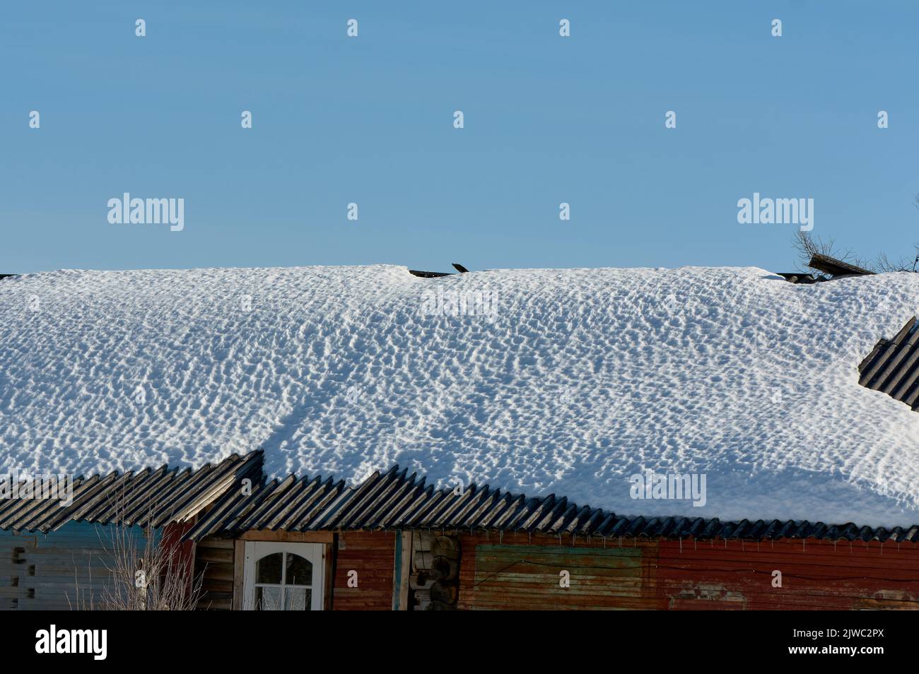 a block of ice hangs from the roof of the house Stock Photo - Alamy
