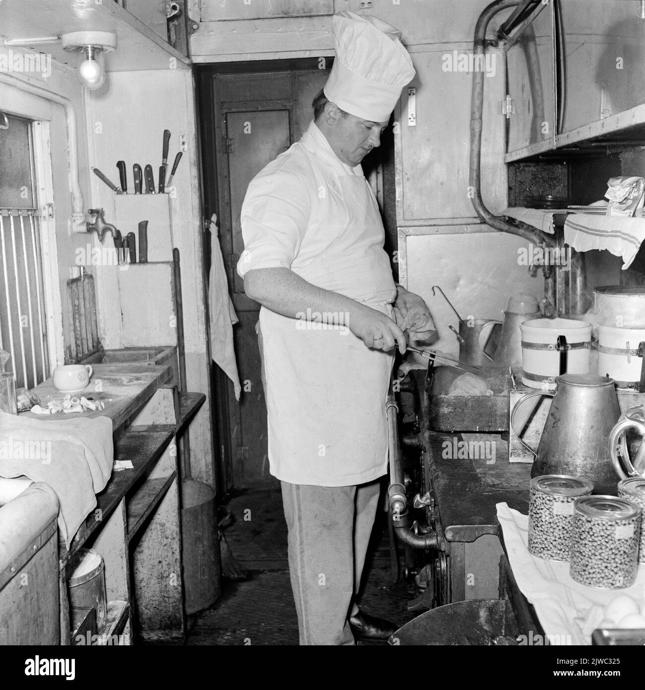 Image of a cook while roasting a chicken in the kitchen of the ...