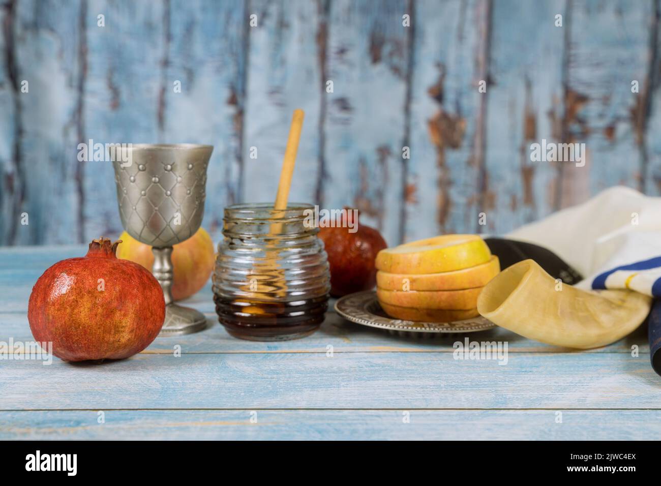Jewish New Year symbols with shofar glass honey jar, fresh apples, and ...