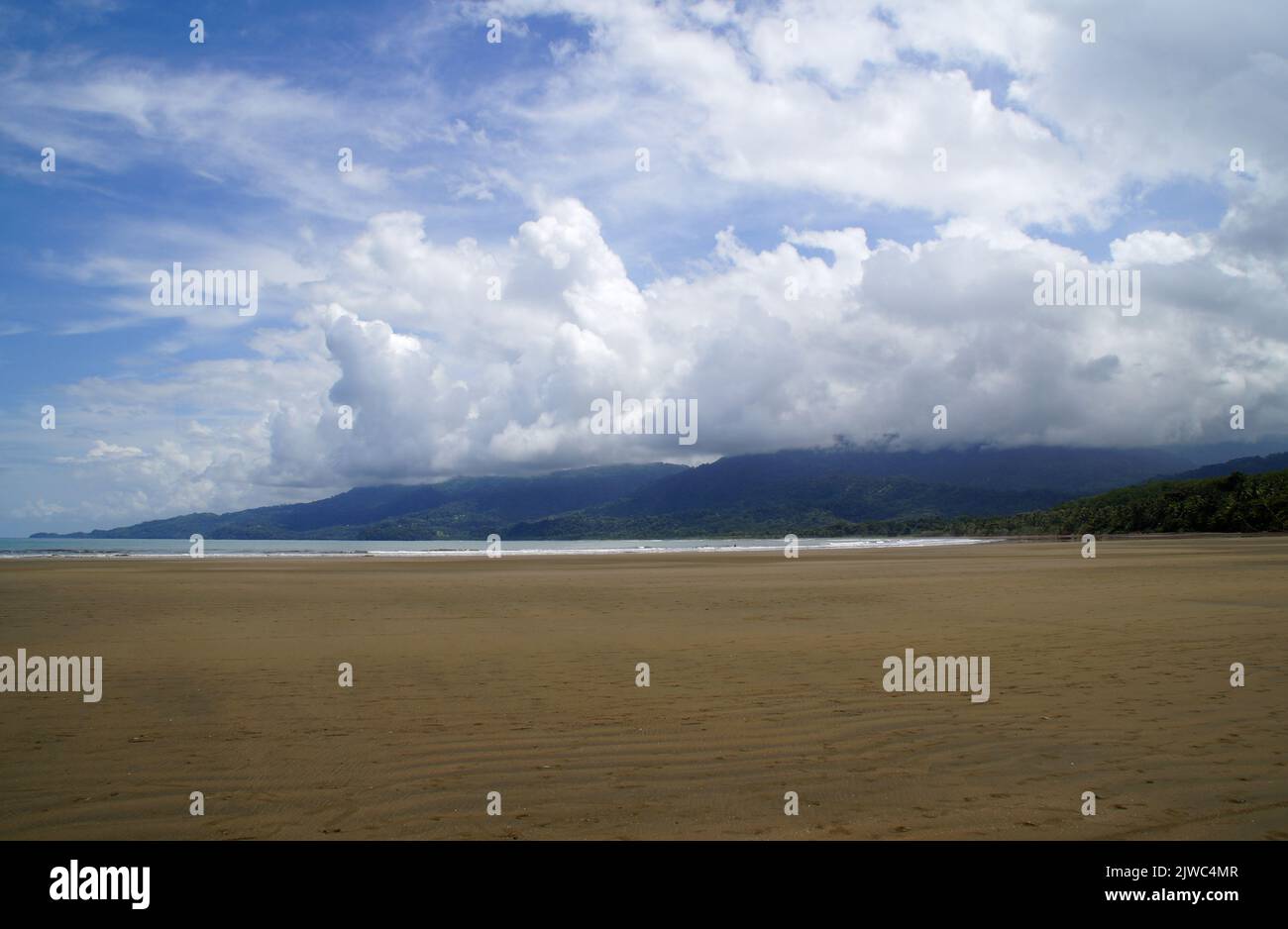 The white clouds in blue sky over sandy beach Stock Photo - Alamy