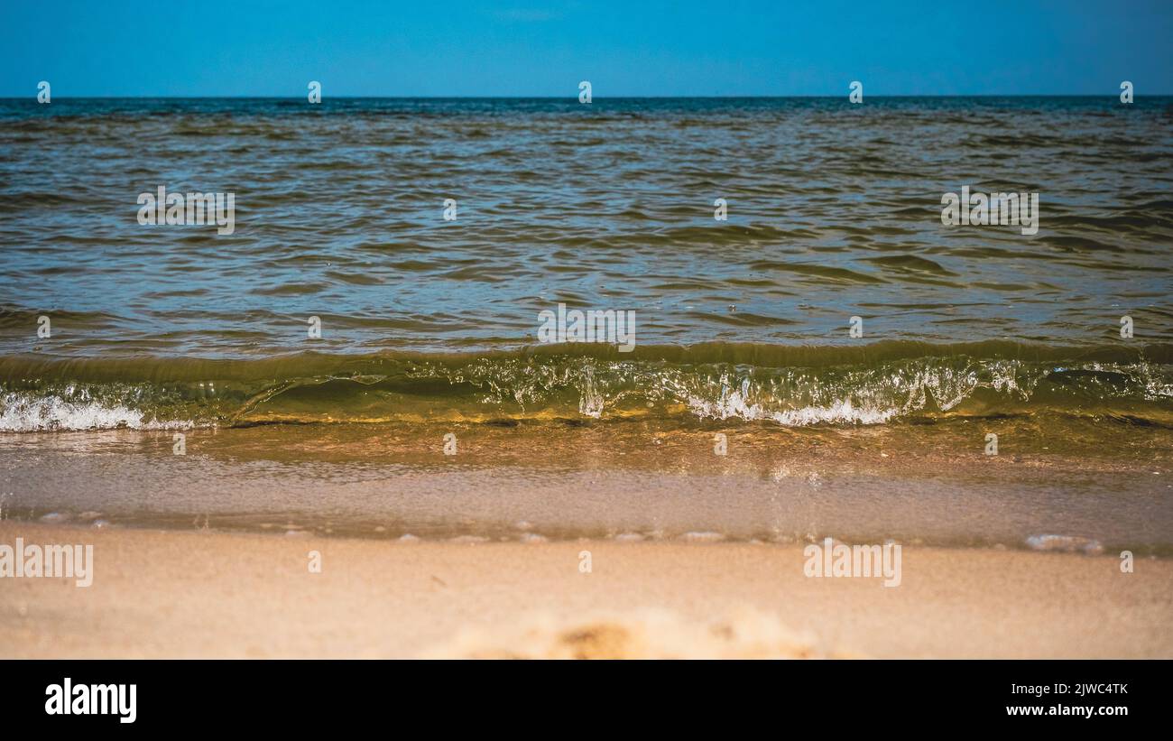 A scenic shot of a sea wave rolling on the shore of a beach Stock Photo - Alamy