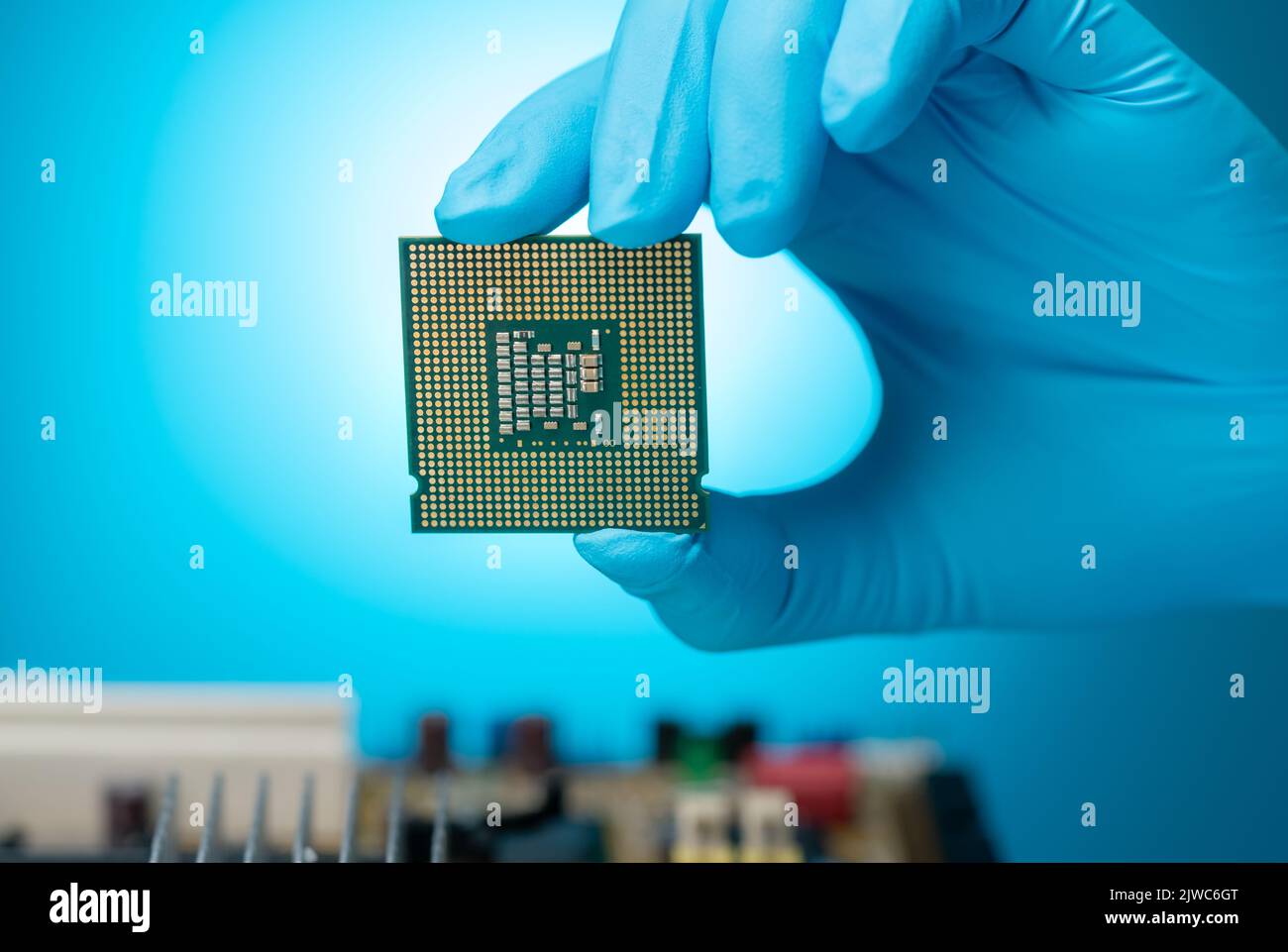 Electronic engineer hand holding computer chip on blue background ... Electronic engineer hand holding computer chip on blue background ...