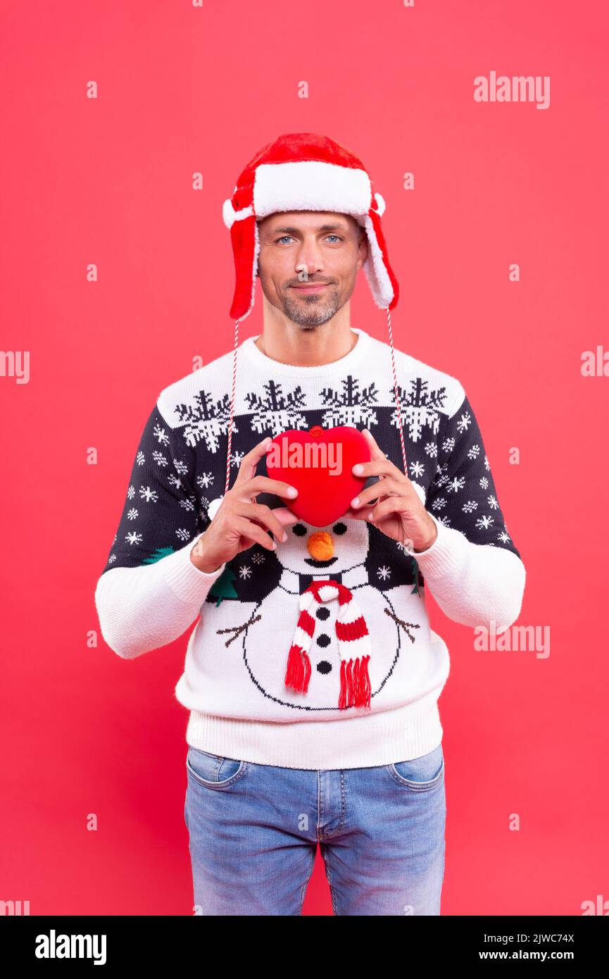 smiling guy hold love heart on red background. express positive ...