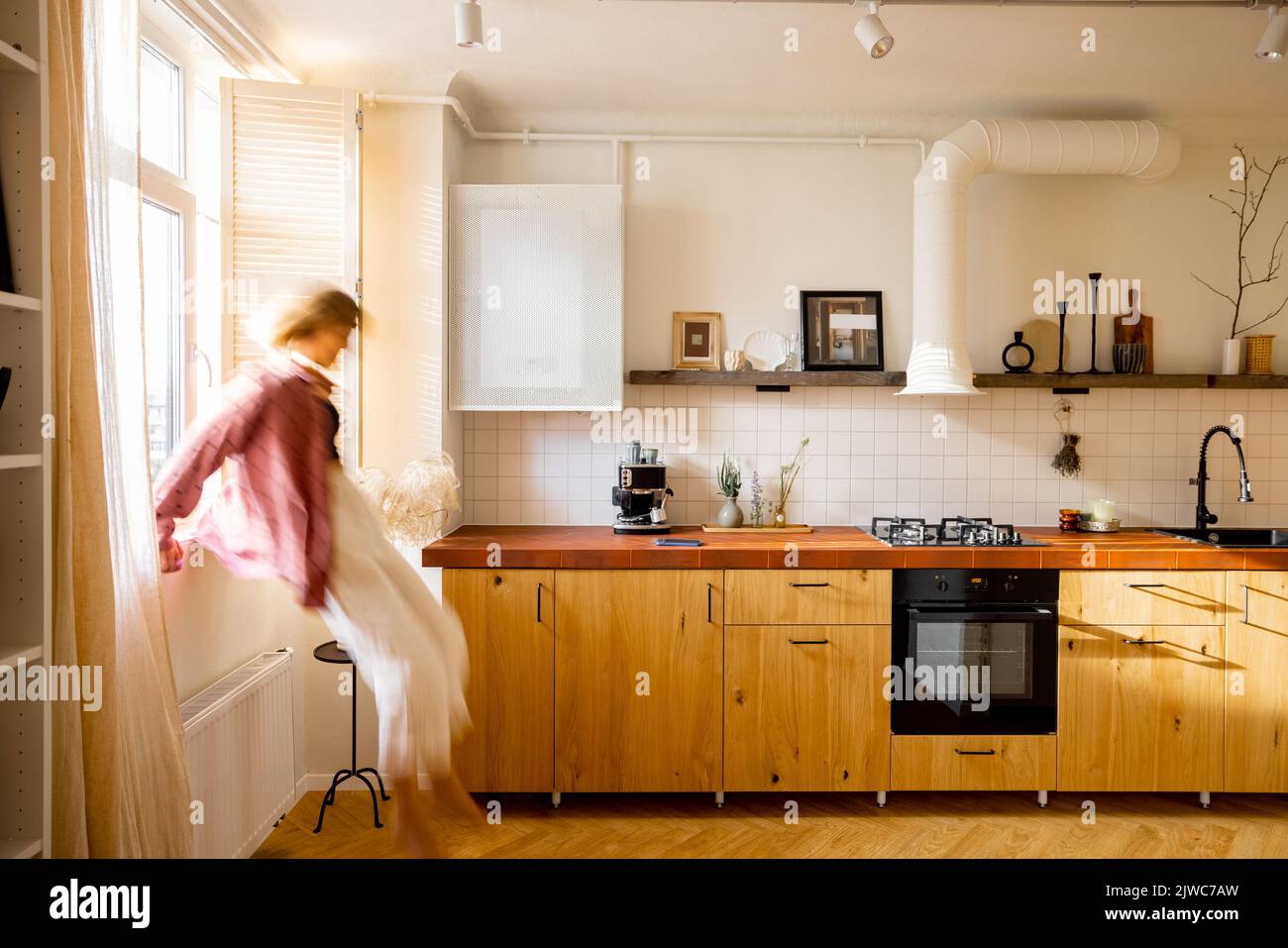 Modern kitchen interior with person sitting on window sill Stock Photo ...