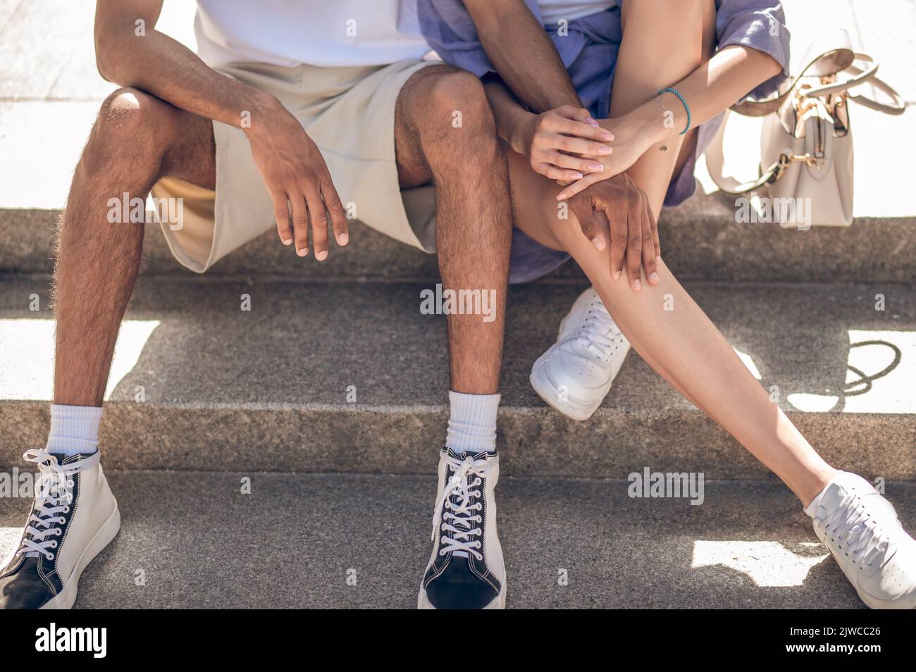 Close up picture of two people sitting close and holding hands Stock ...