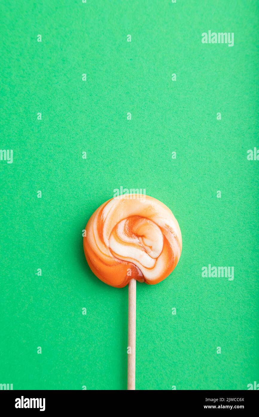 Single lollipop candy on green pastel background. copy space, top view ...