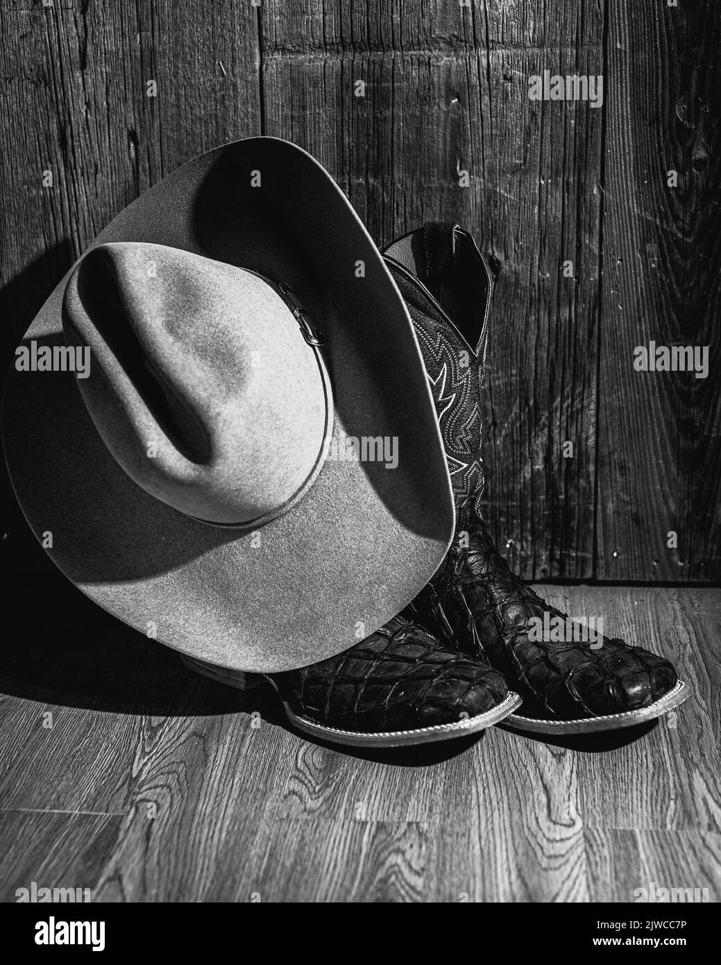 A vertical closeup of boots and an old-fashioned hat shot in grayscale ...