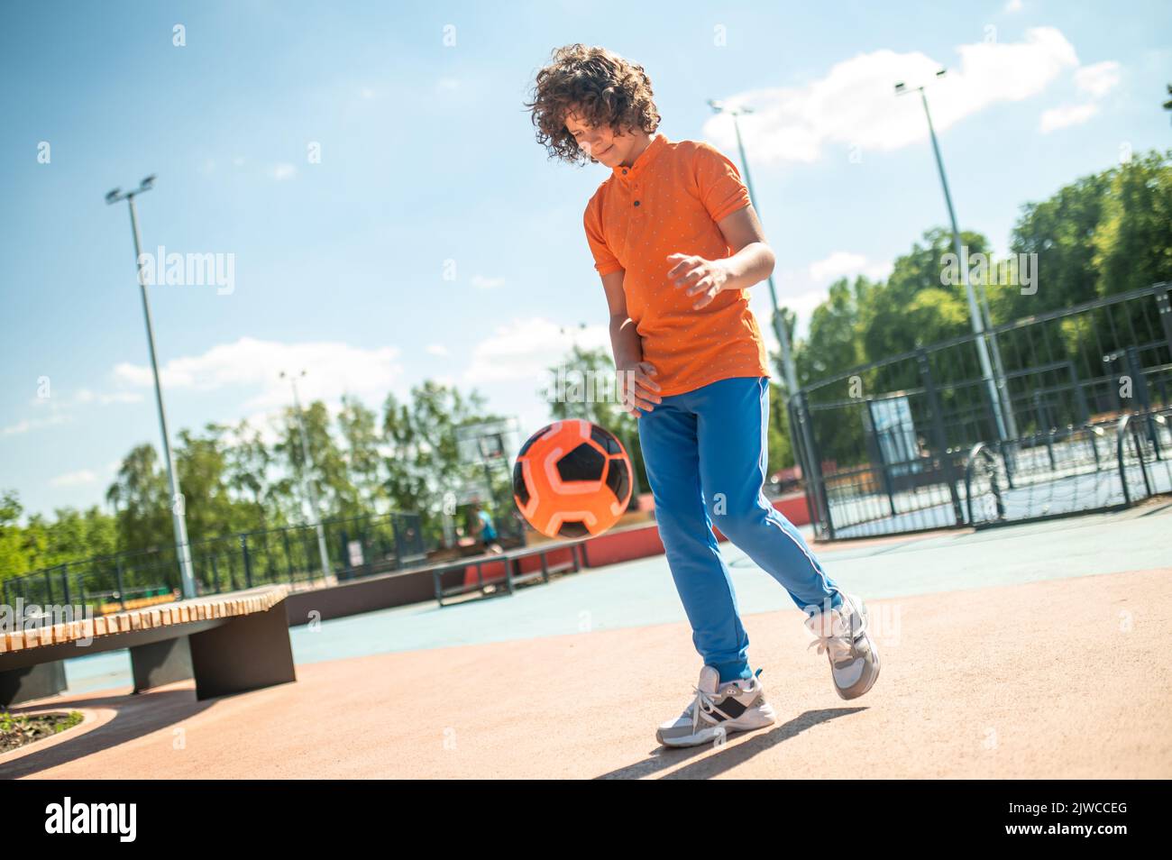 Focused adolescent practicing a ball kick technique Stock Photo - Alamy