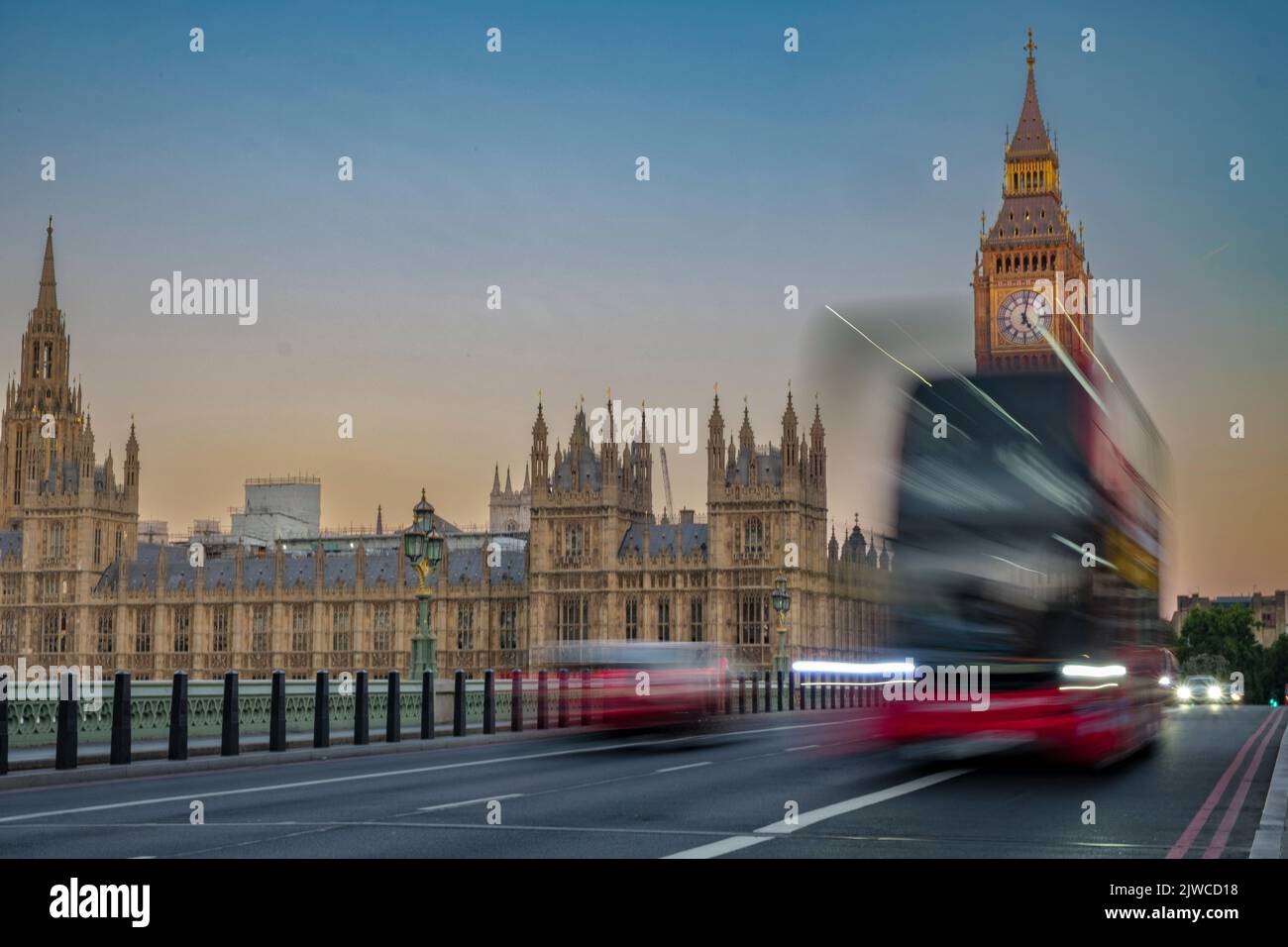 Low angle shot of Westminster Bridge and Parliament at dawn with bus ...