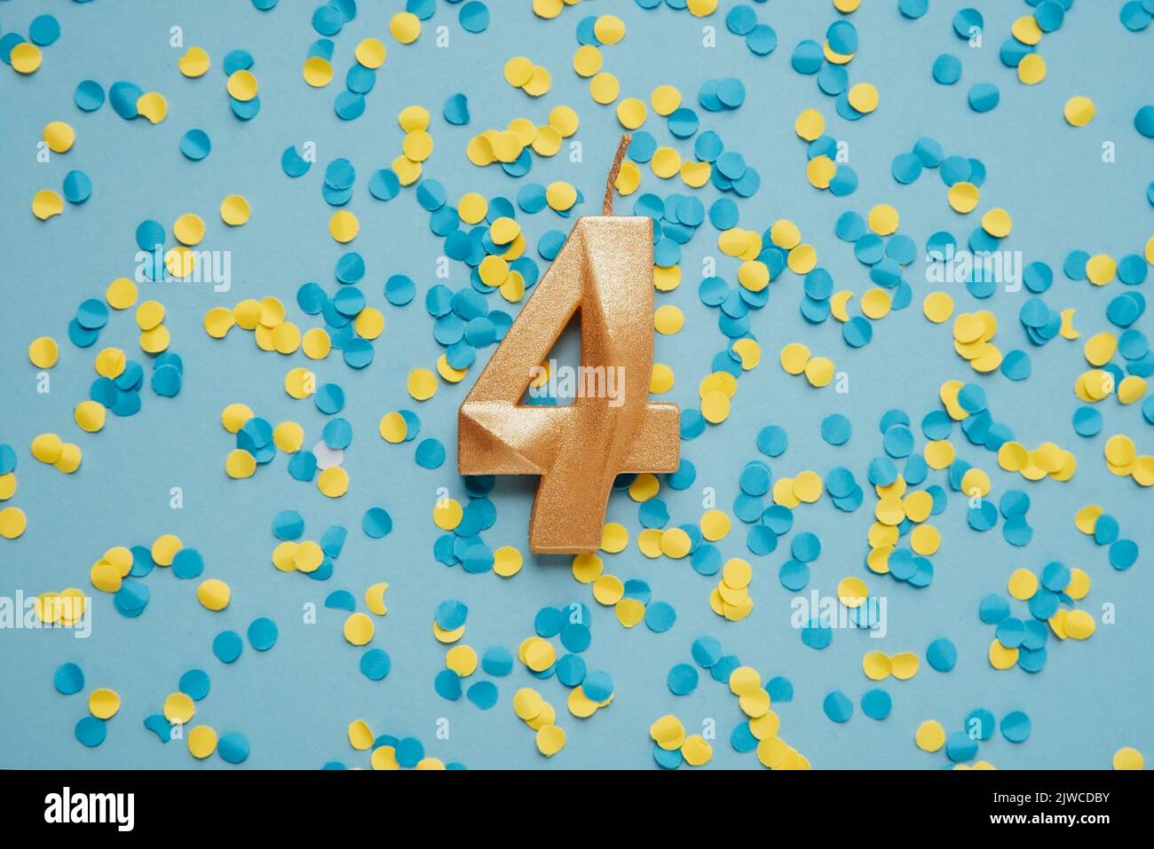 Number 4 four golden celebration birthday candle on yellow and blue ...