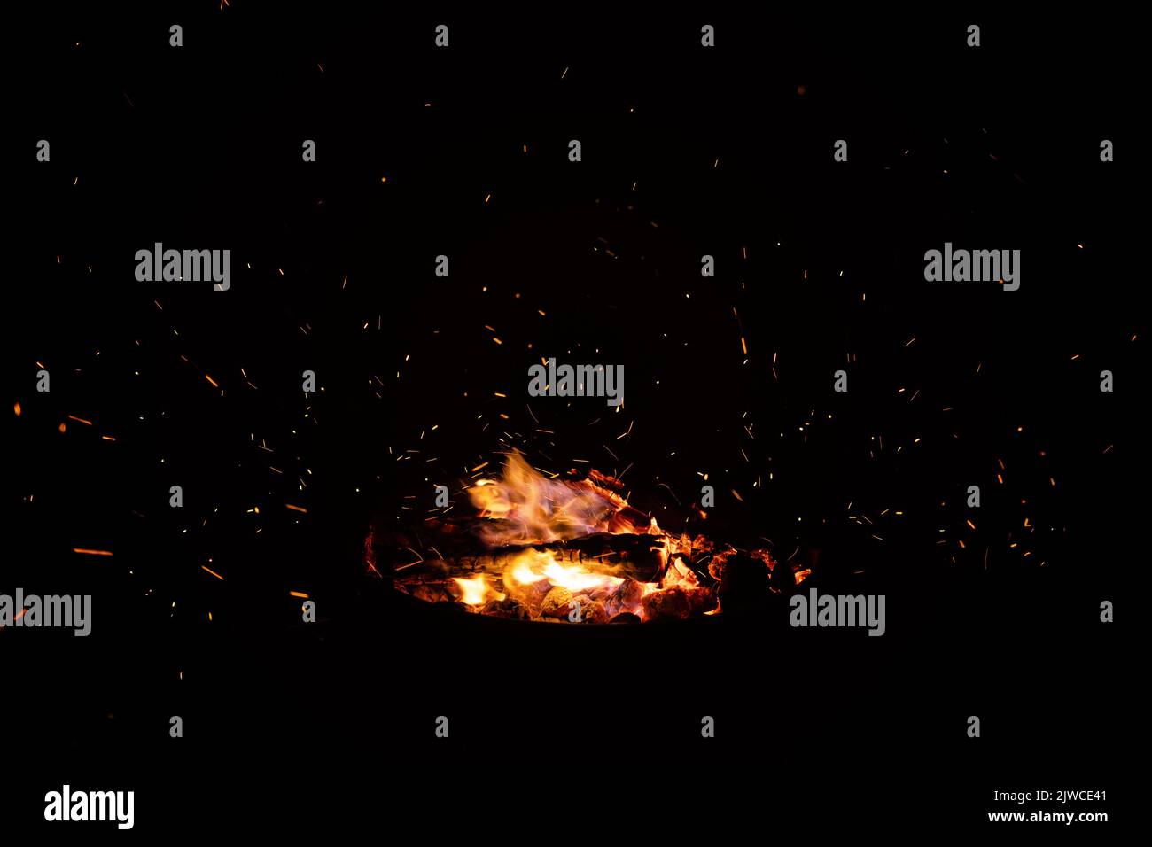 Campfire flame sparks isolated on black background. Fire flames heat ...