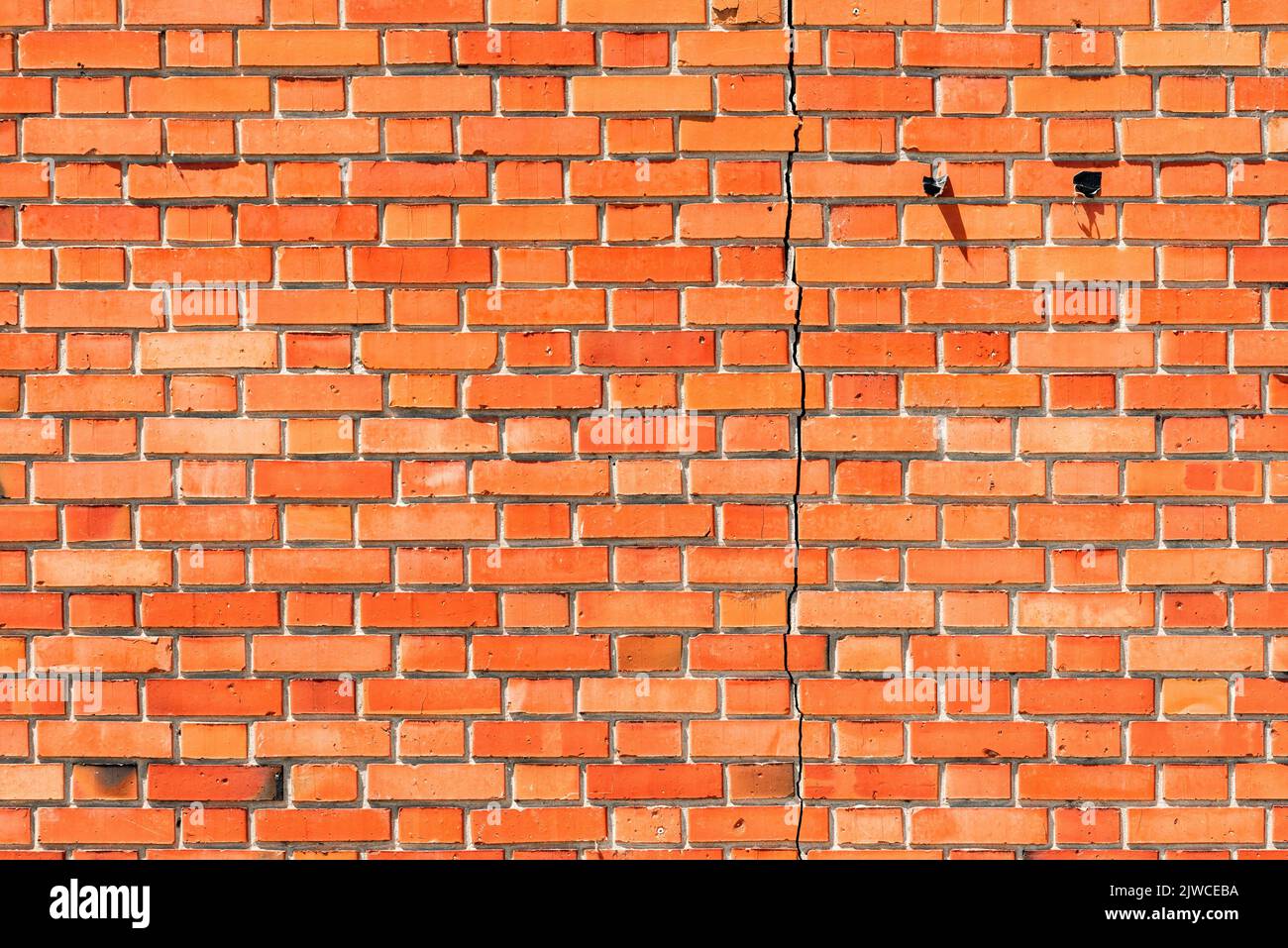 Cracked damaged orange brick wall facade as background and texture ...