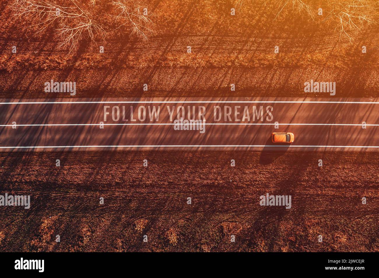 Follow your dreams motivational message on asphalt road through ...