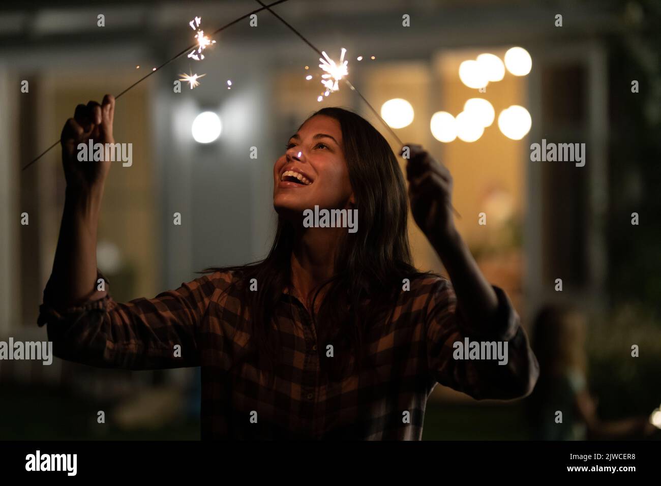 Caucasian woman holding two sparklers Stock Photo - Alamy