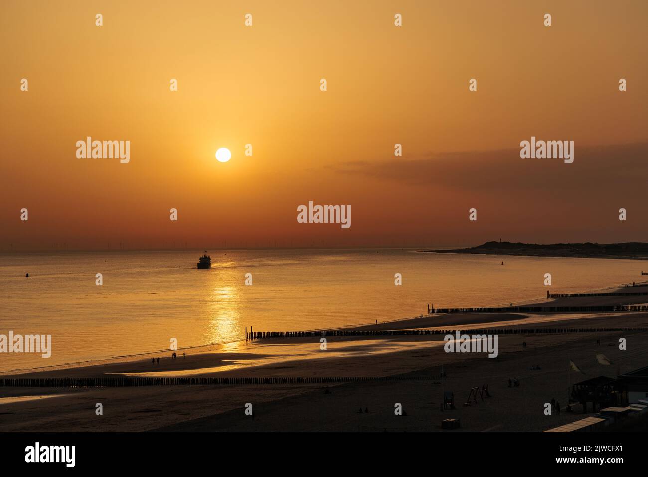 The view of a beach coastline under the golden sunset sky Stock Photo ...