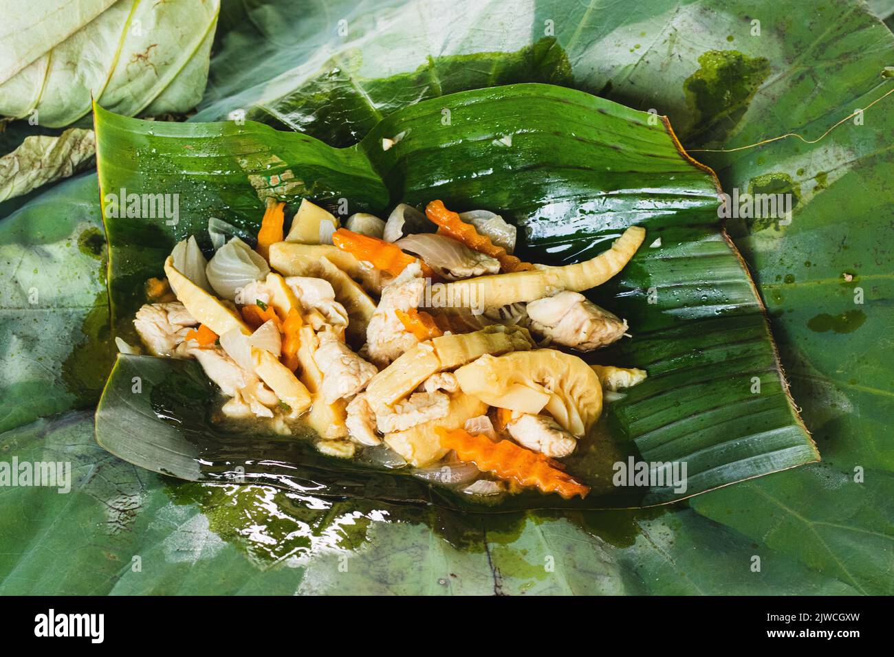 Stir-Fried bamboo shoots with pork served on a banana leaf, a ...