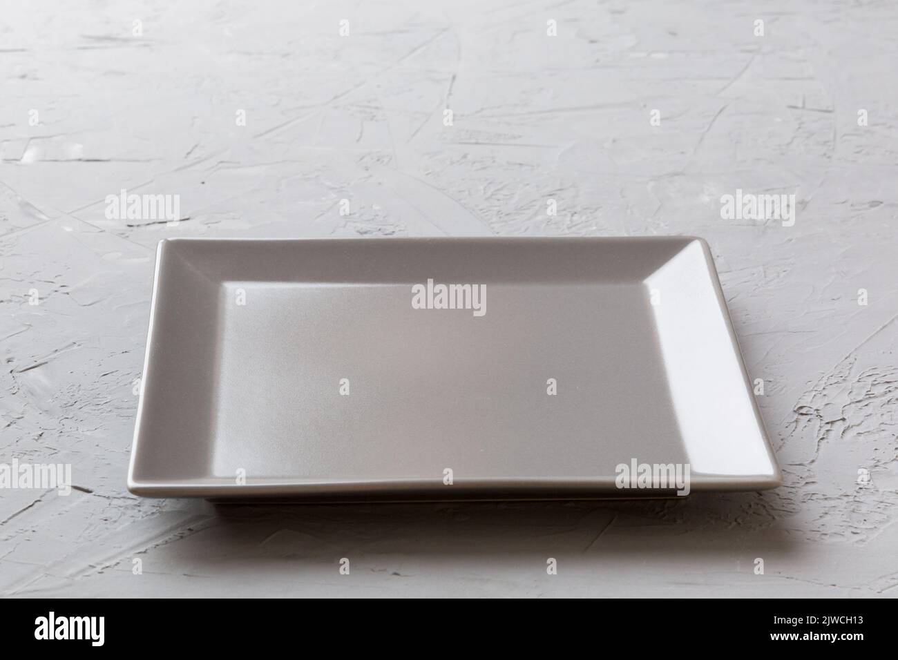 Perspective view of empty square plate on cement background. Empty ...