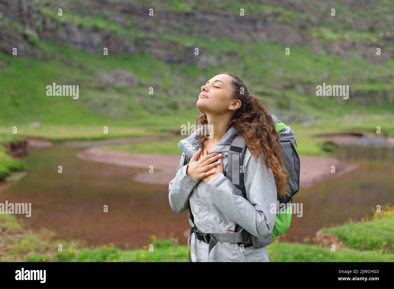 Relaxed hiker breathing fresh air with hands on chest in nature Stock ...